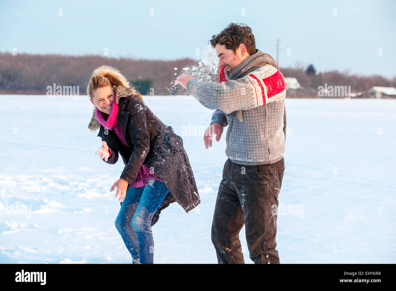 Couple having snowball fight Stock Photo - Alamy