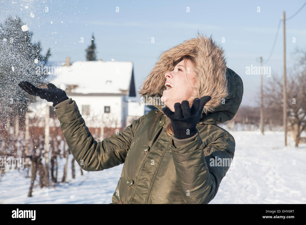 Young woman throwing snow in the air Stock Photo - Alamy