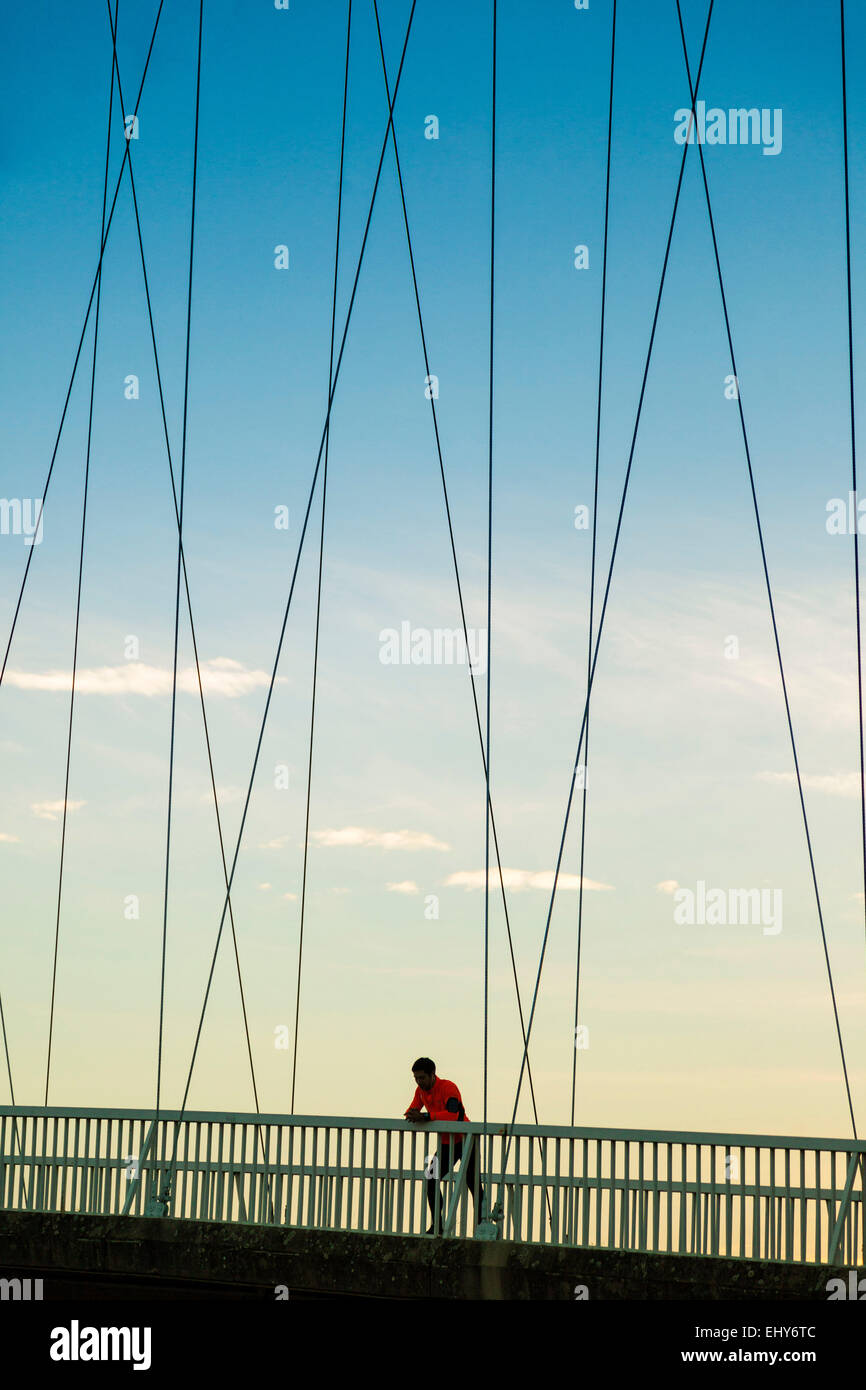 Male runner on bridge takes a break Stock Photo - Alamy