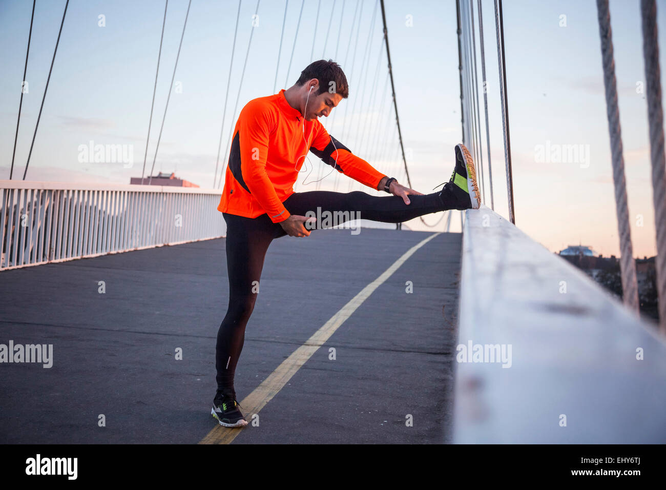 Man on bridge stretching and warming up Stock Photo - Alamy