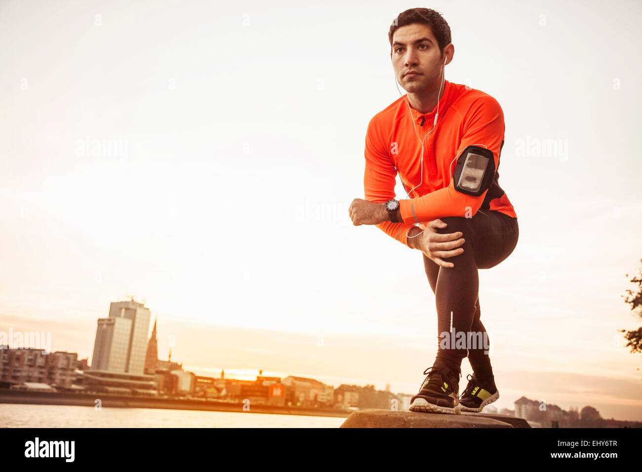 Male runner stretching and warming up against skyline Stock Photo - Alamy