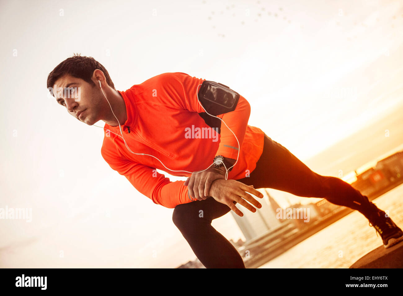 Male runner stretching and warming up at sunset Stock Photo - Alamy