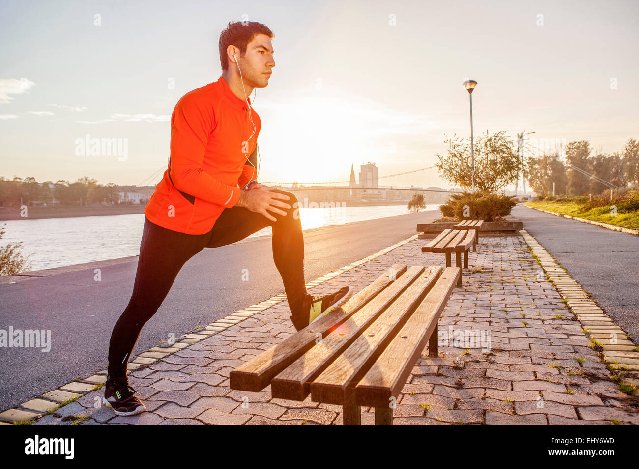 Male runner stretching and warming up at sunset Stock Photo - Alamy