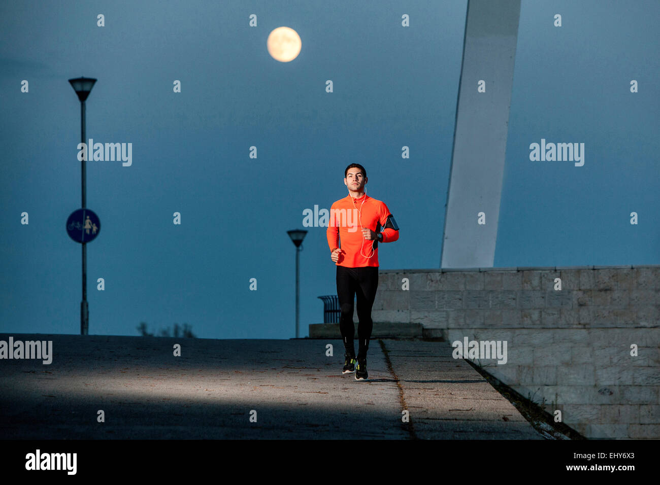 Male runner jogging against full moon Stock Photo - Alamy