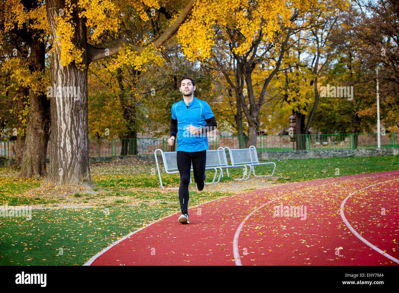 Male runner jogging on running track Stock Photo - Alamy
