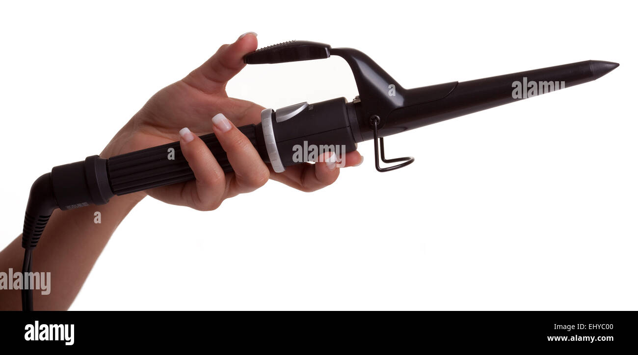A hand holding a curling hair tool Stock Photo - Alamy