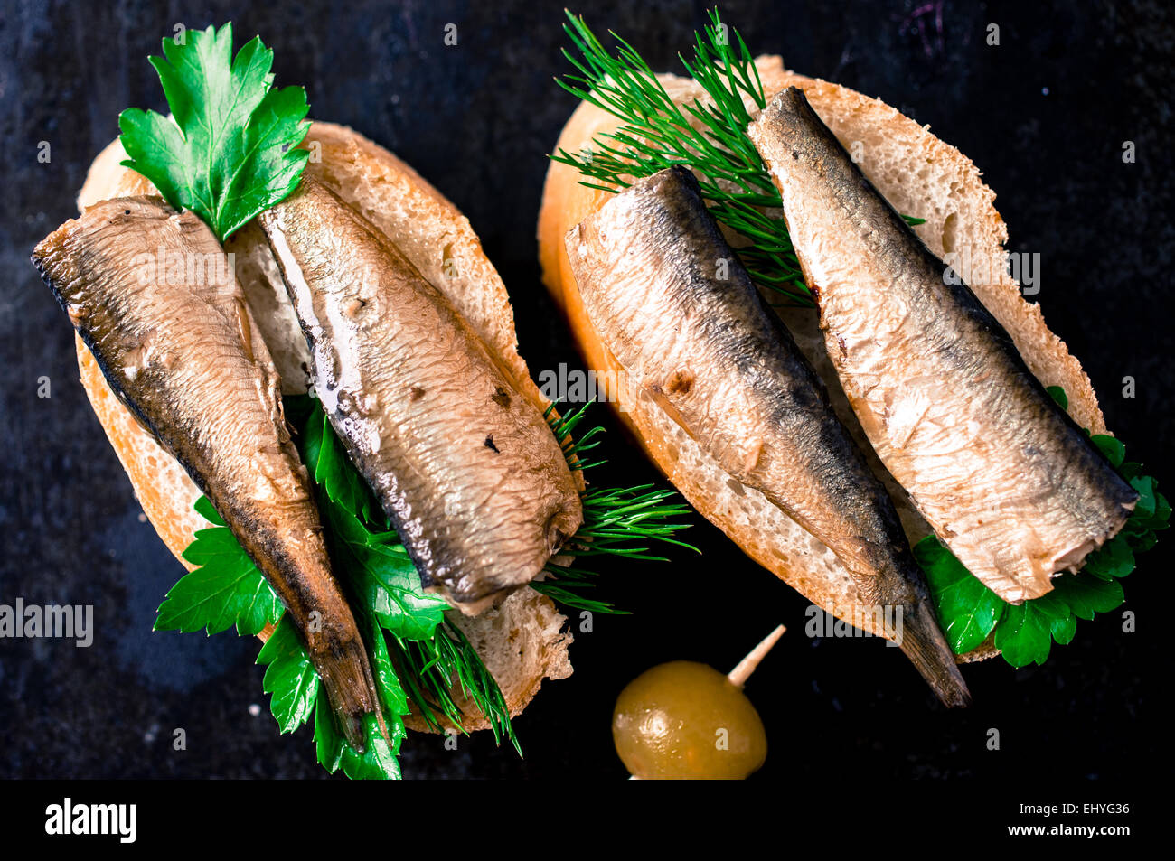 Tapas snack with fish sprats, parsley, dill and olives Stock Photo - Alamy