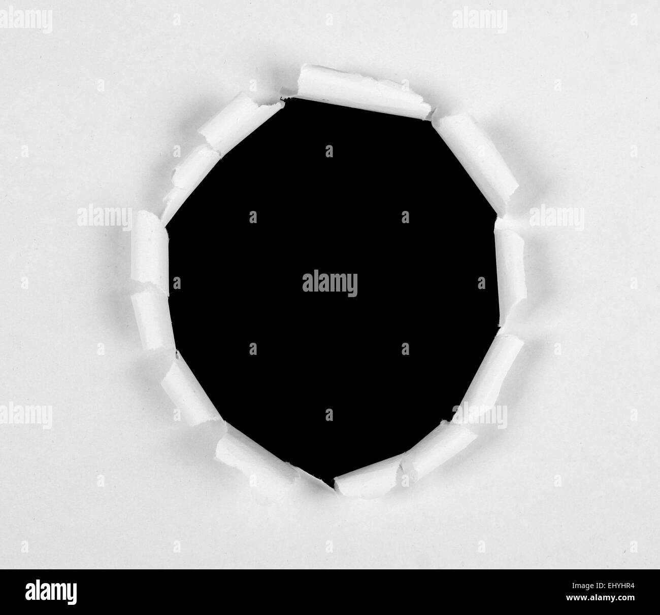 Hole in the paper sheet over black background Stock Photo - Alamy