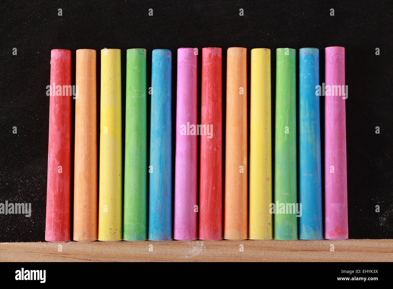 All kinds of colorful chalks on blackboard background Stock Photo - Alamy