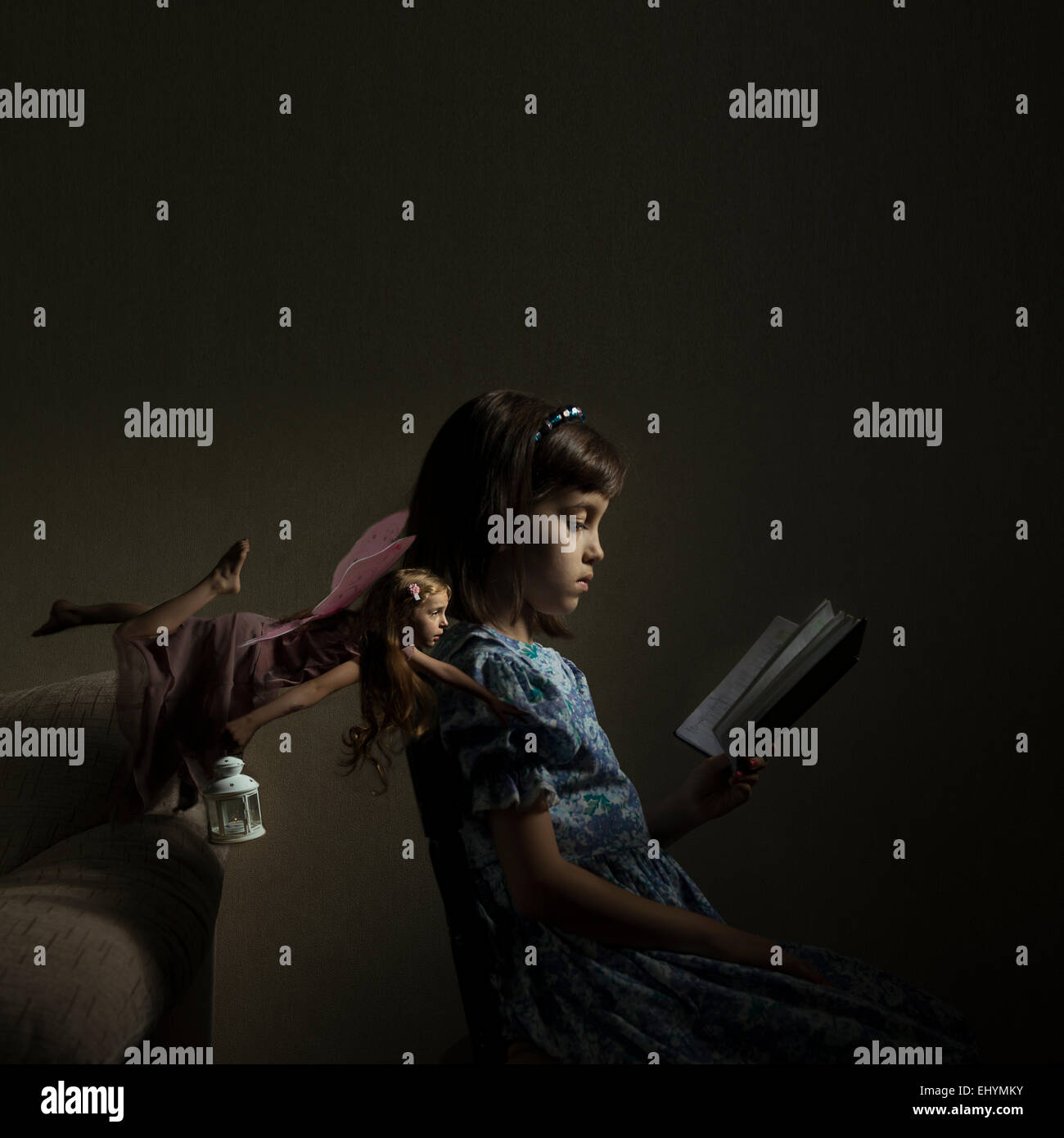 Girl reading a book with a little fairy looking over her shoulder Stock ...