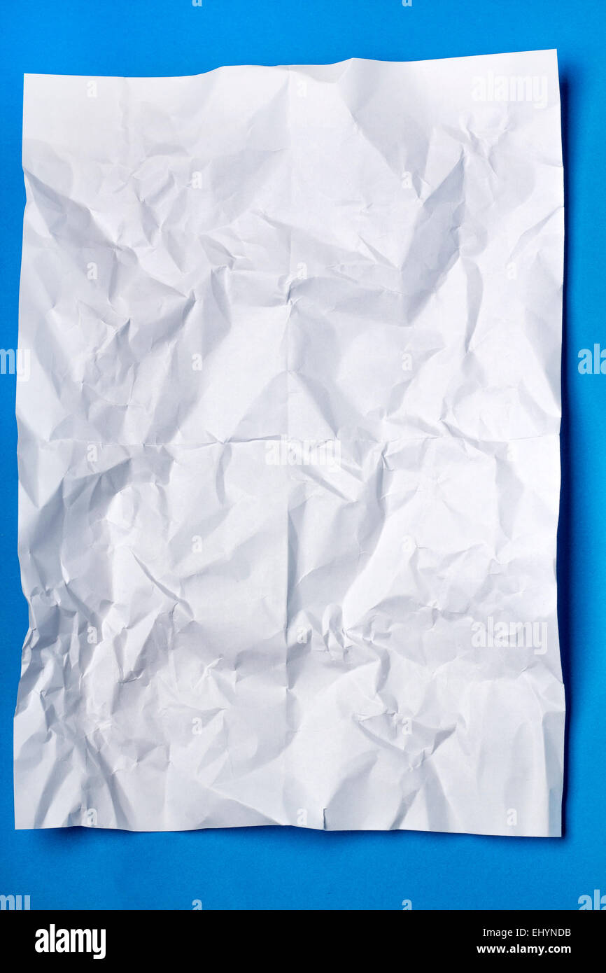 Wrinkled white piece of paper over a blue background Stock Photo - Alamy