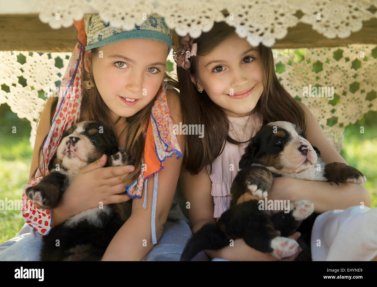 Two girls sitting with puppies Stock Photo - Alamy