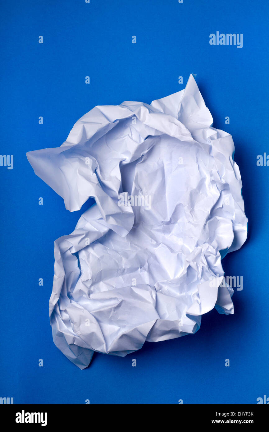 Wrinkled white piece of paper over a blue background Stock Photo - Alamy