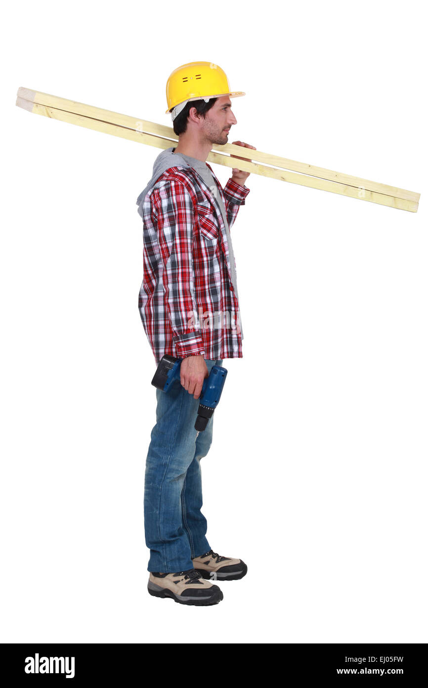 carpenter standing in profile holding ruler over his shoulder Stock ...