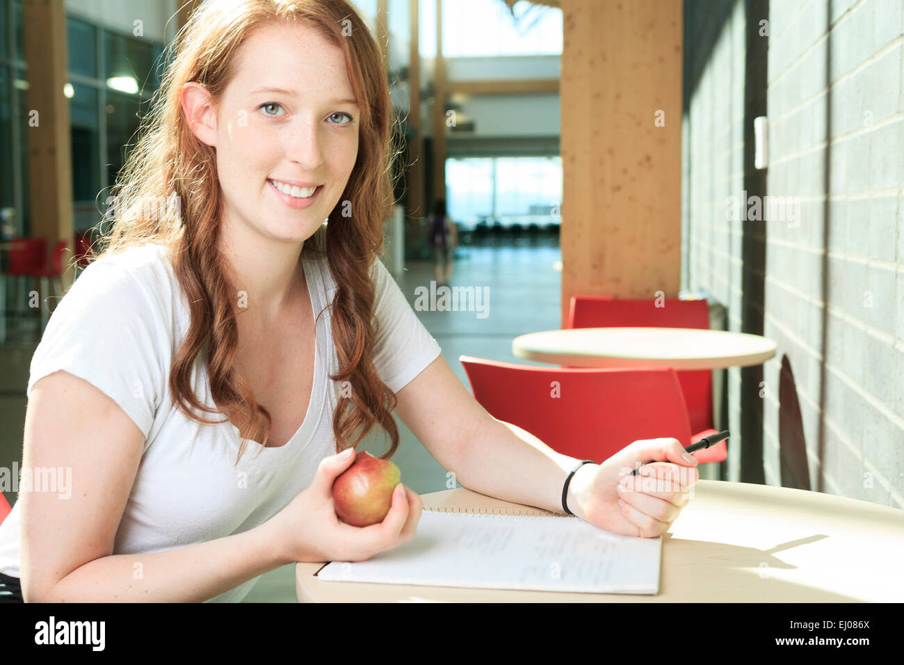 University / college student girl looking happy smiling with boo Stock ...