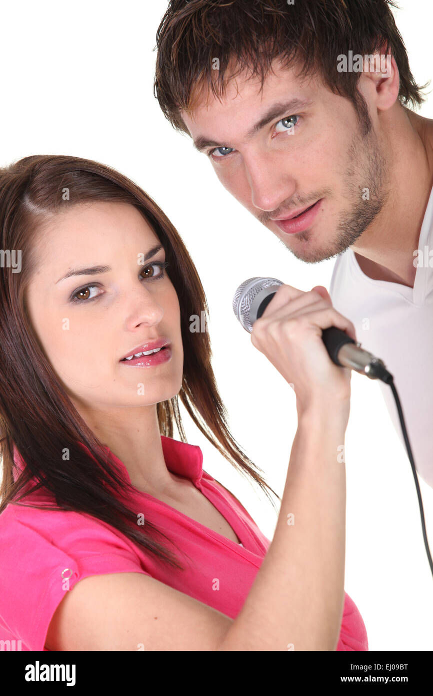 Young couple singing into a microphone Stock Photo - Alamy