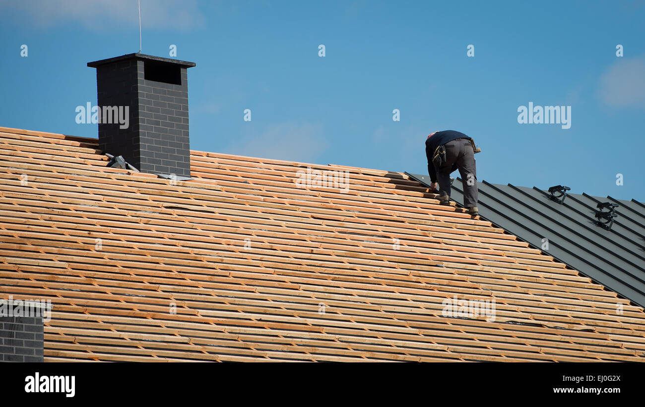 Building crew working on the roof sheeting Stock Photo - Alamy