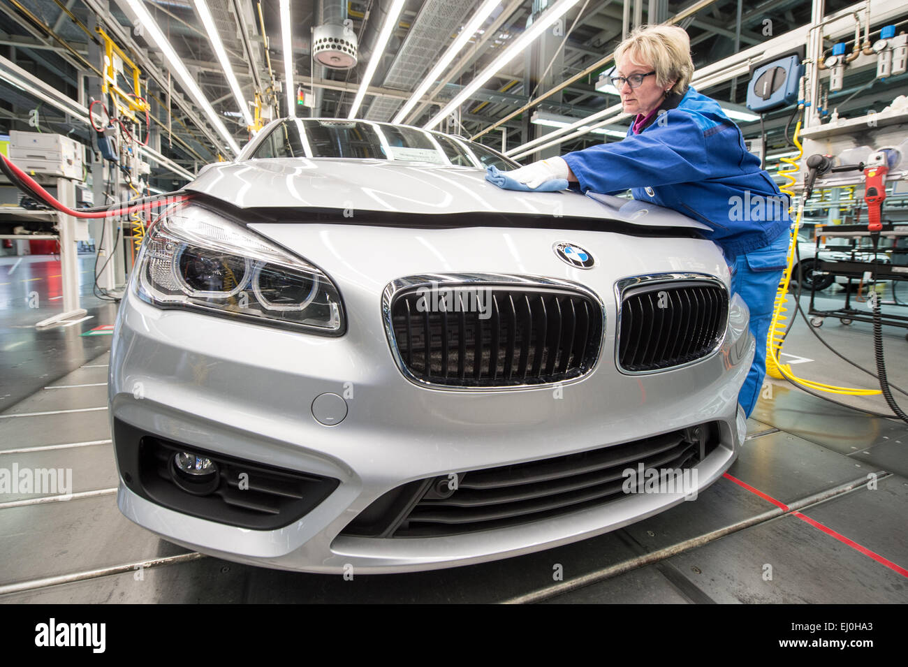 A staff member works on the finishing touches of a BMW Gran Tourer car ...