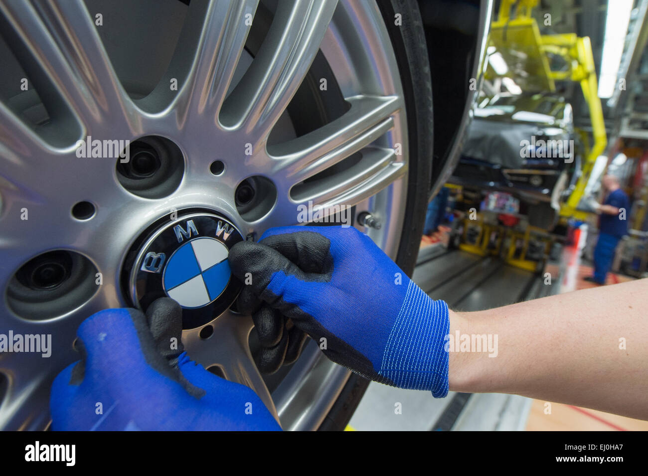 A staff member attaches the BMW logo to a wheel of a BMW car model at ...