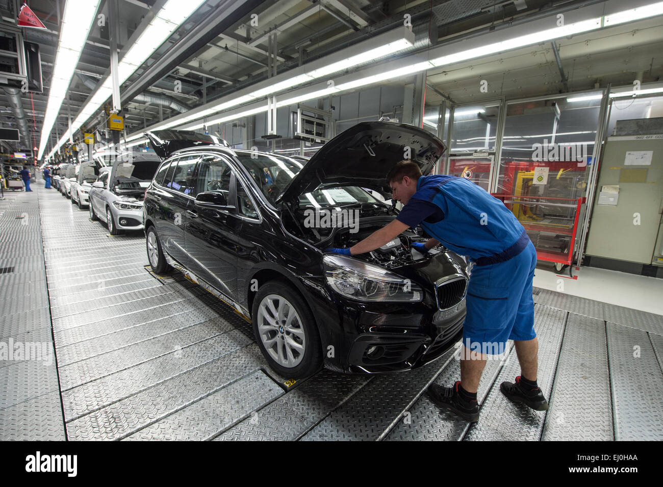 A staff member works on the assembly of a BMW Gran Tourer car model at ...