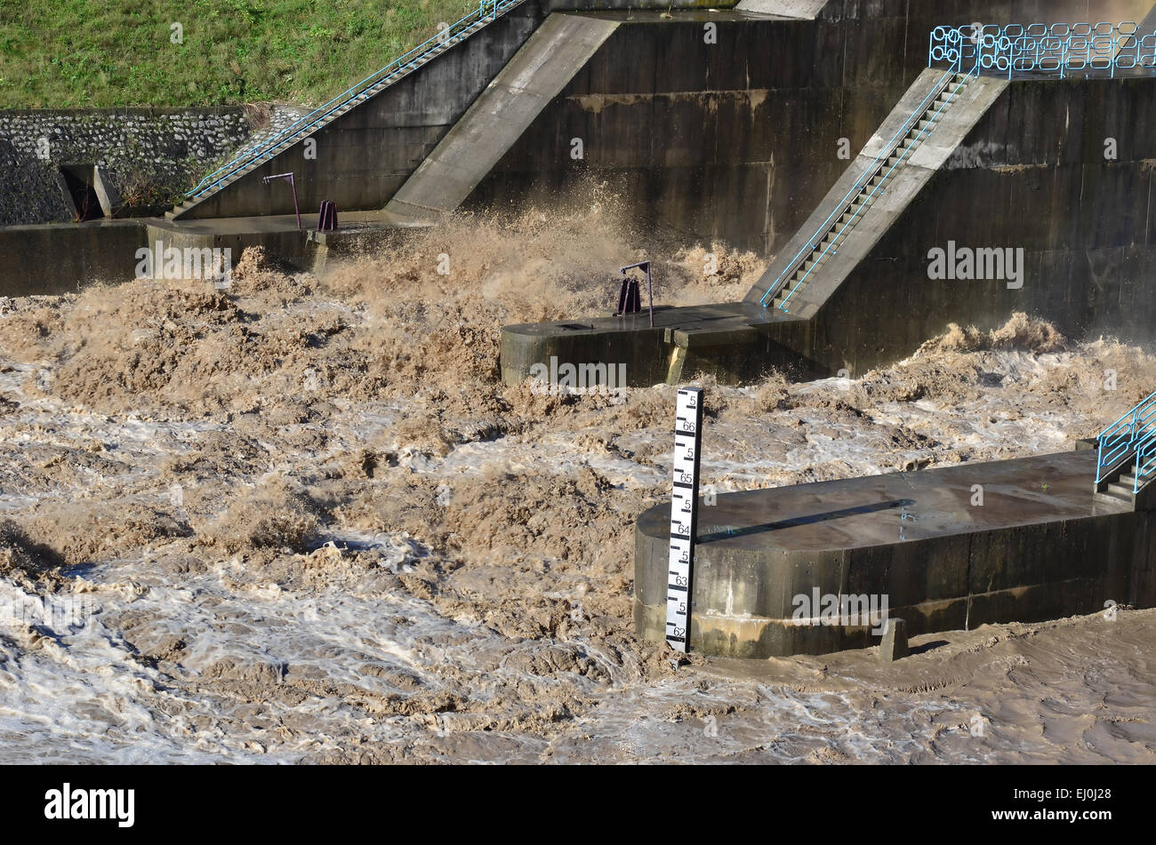 Flood water bursting over a dam, after extremely high rainfall ...