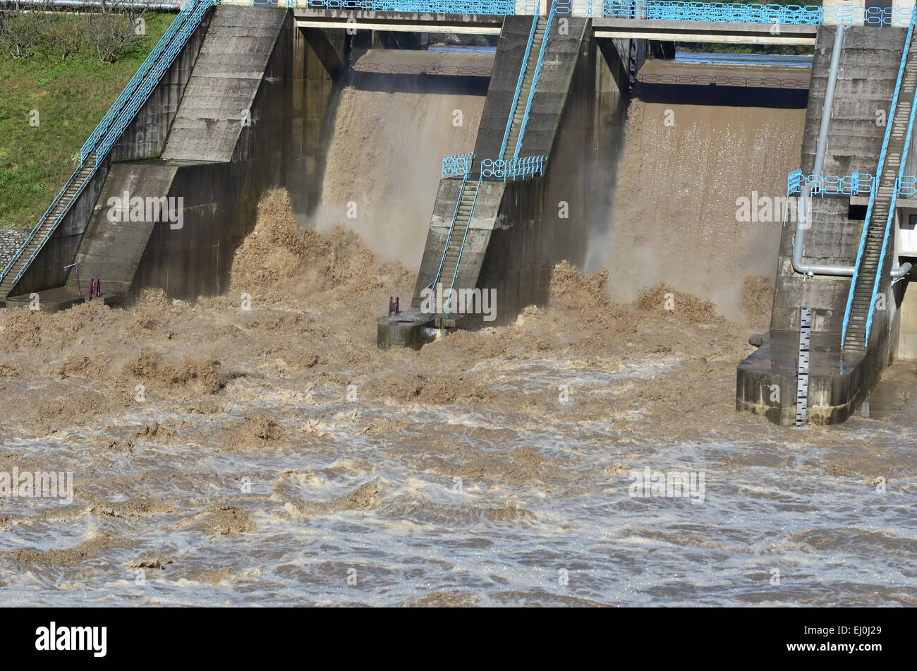 Flood water streaming ove the top of a dam caused by excessive rainfall ...