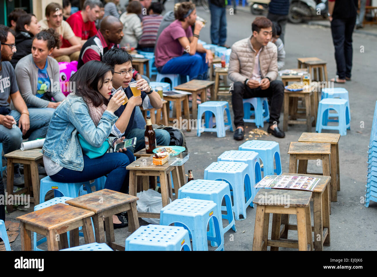 Young Vietnamese people at an outdoor restaurant in the old quarter of ...