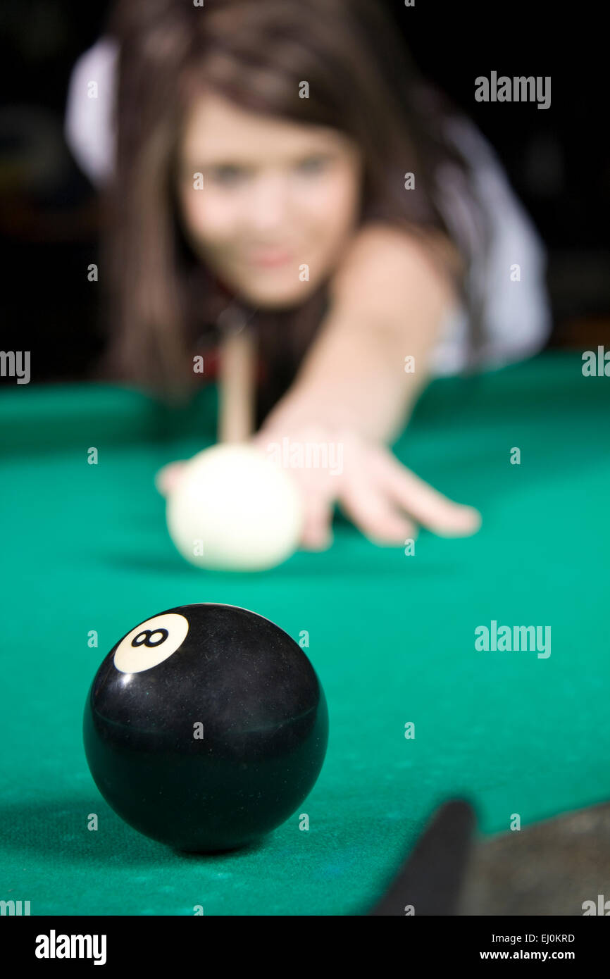 Girl playing snooker in the dark club Stock Photo - Alamy