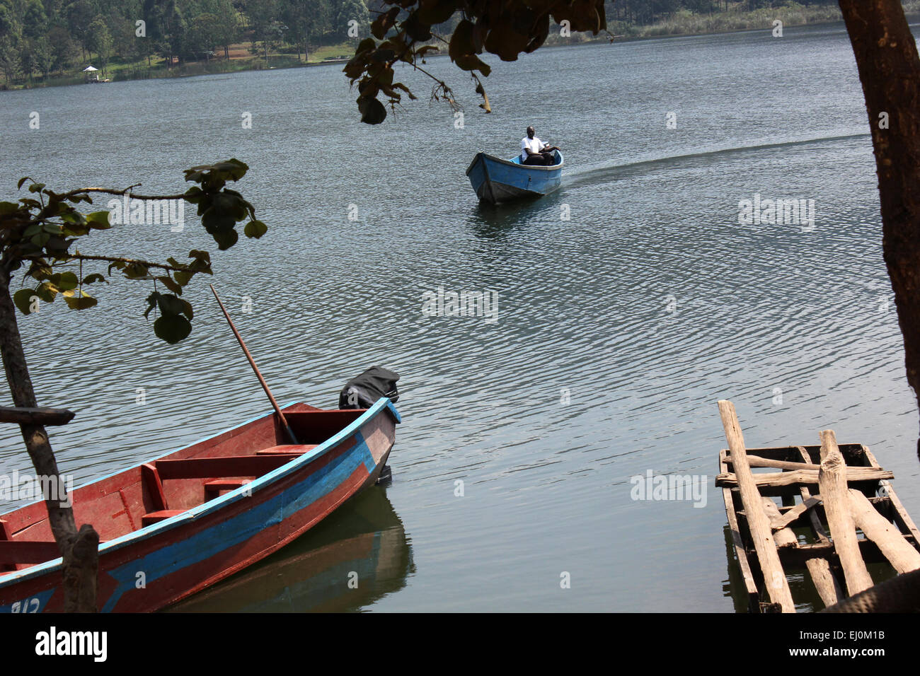 A man rides a boat on Lake Bunyonyi, Africa's deepest fresh water body ...