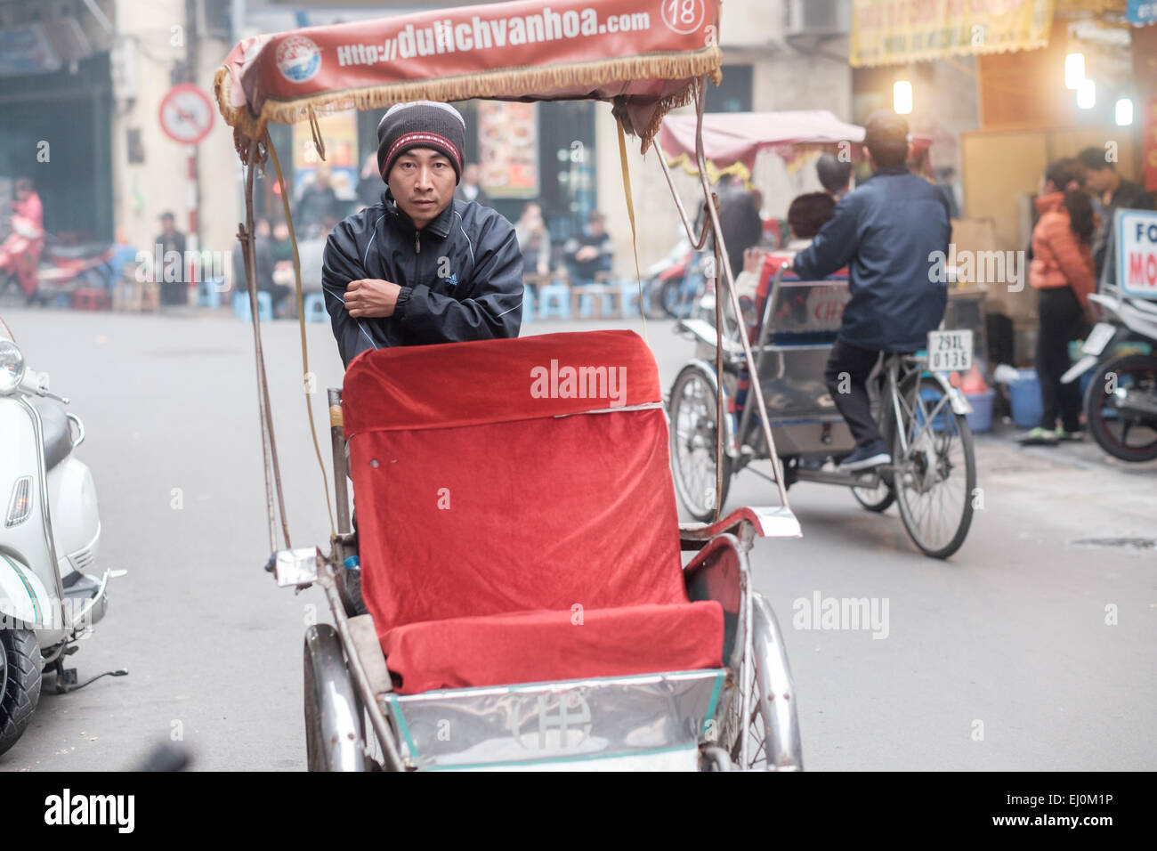 Rickshaw driver waits for customers in the old quarter of Hanoi ...