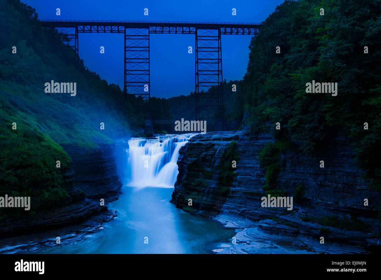 Upper Falls and a train bridge during twilight, at Letchworth State ...