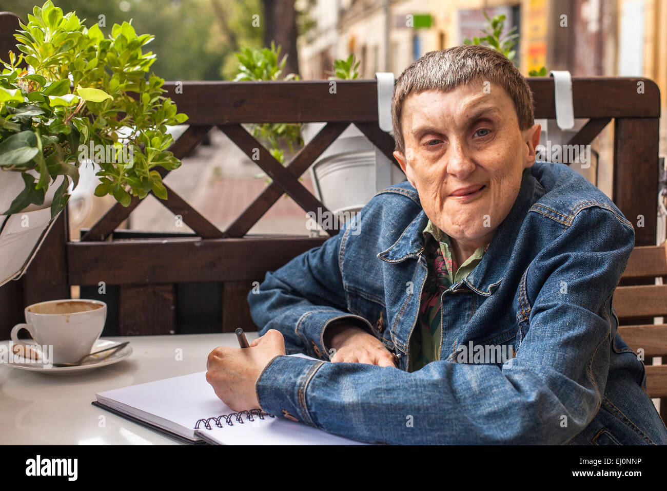 Disabled man with palsy, smiling sitting at an outdoor cafe Stock Photo ...