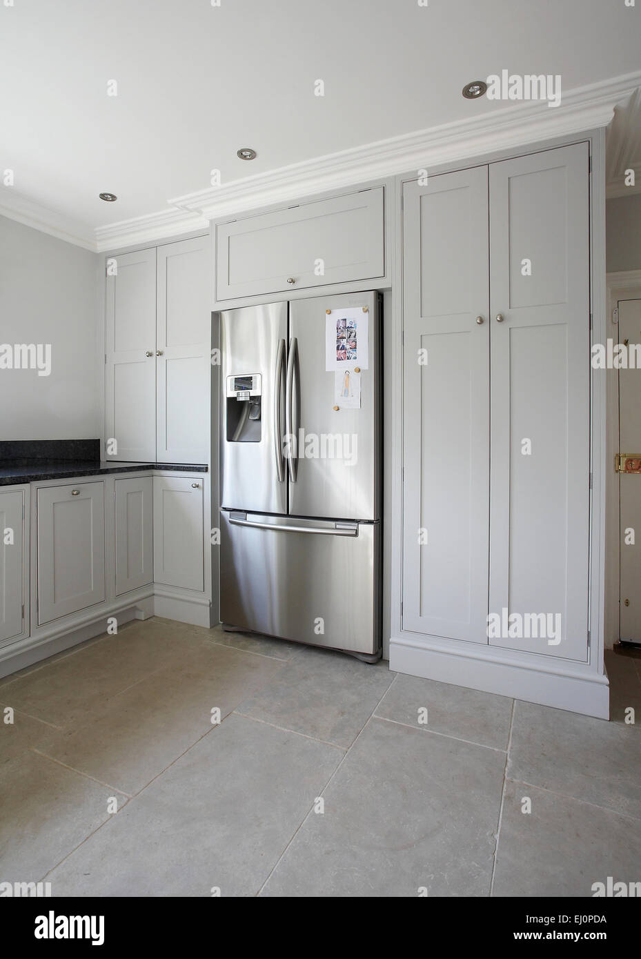 A modern white kitchen in a home in the UK with a stainless steel ...