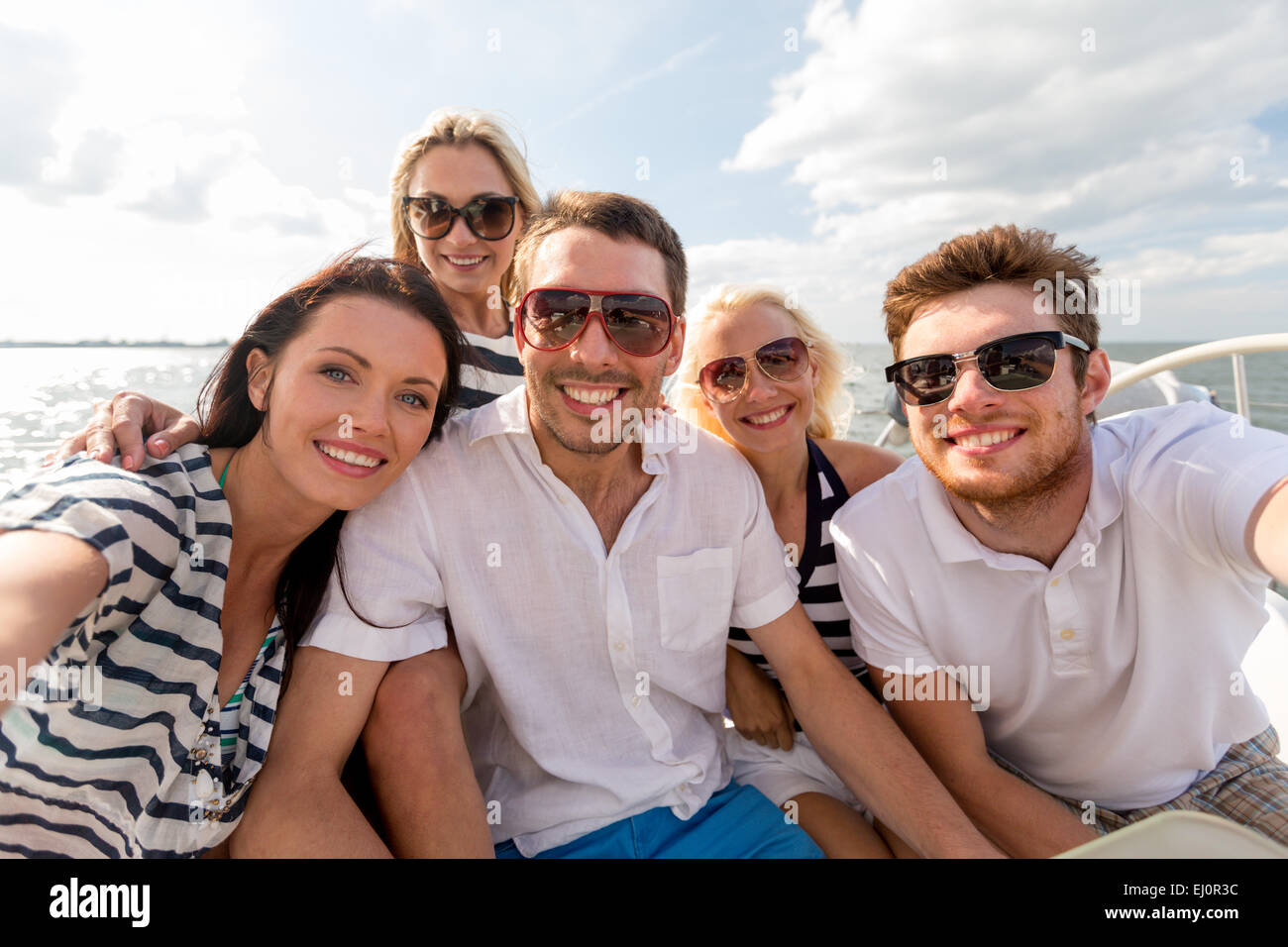 smiling friends sitting on yacht deck Stock Photo - Alamy