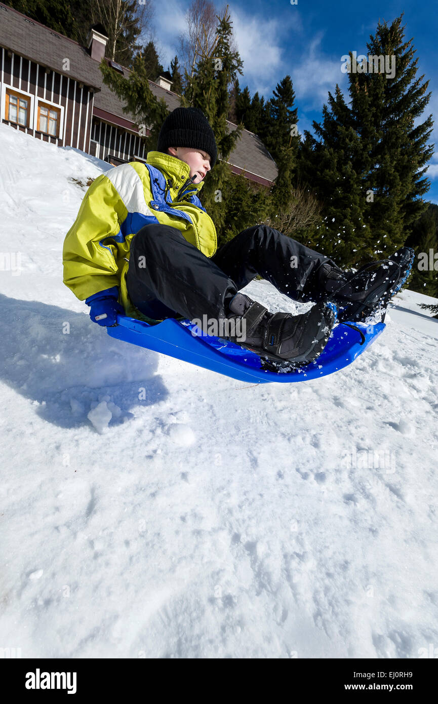 boys riding snow plastic sled in wintertime Stock Photo - Alamy