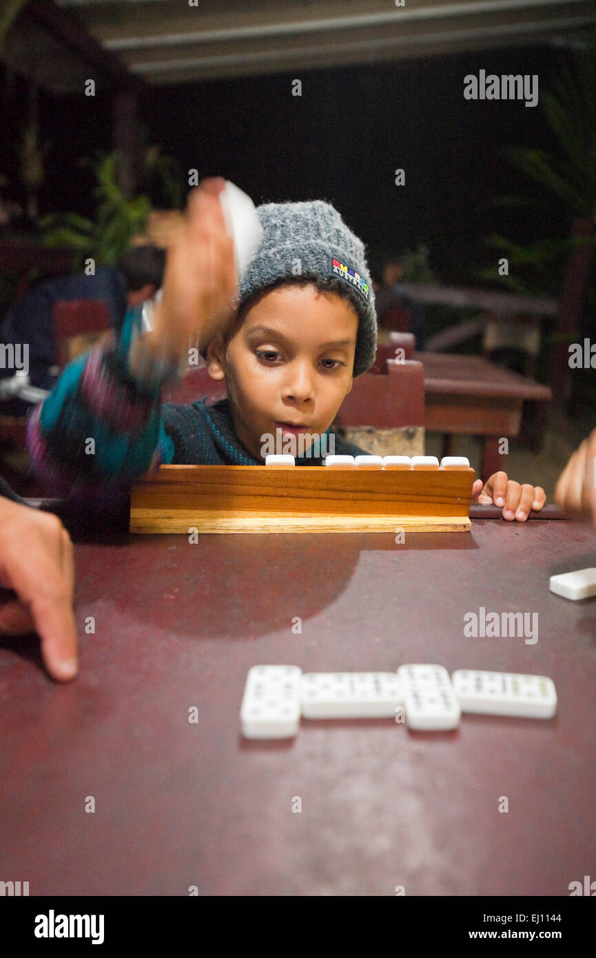 Vertical view of a young boy smacking down the bone in a game of ...