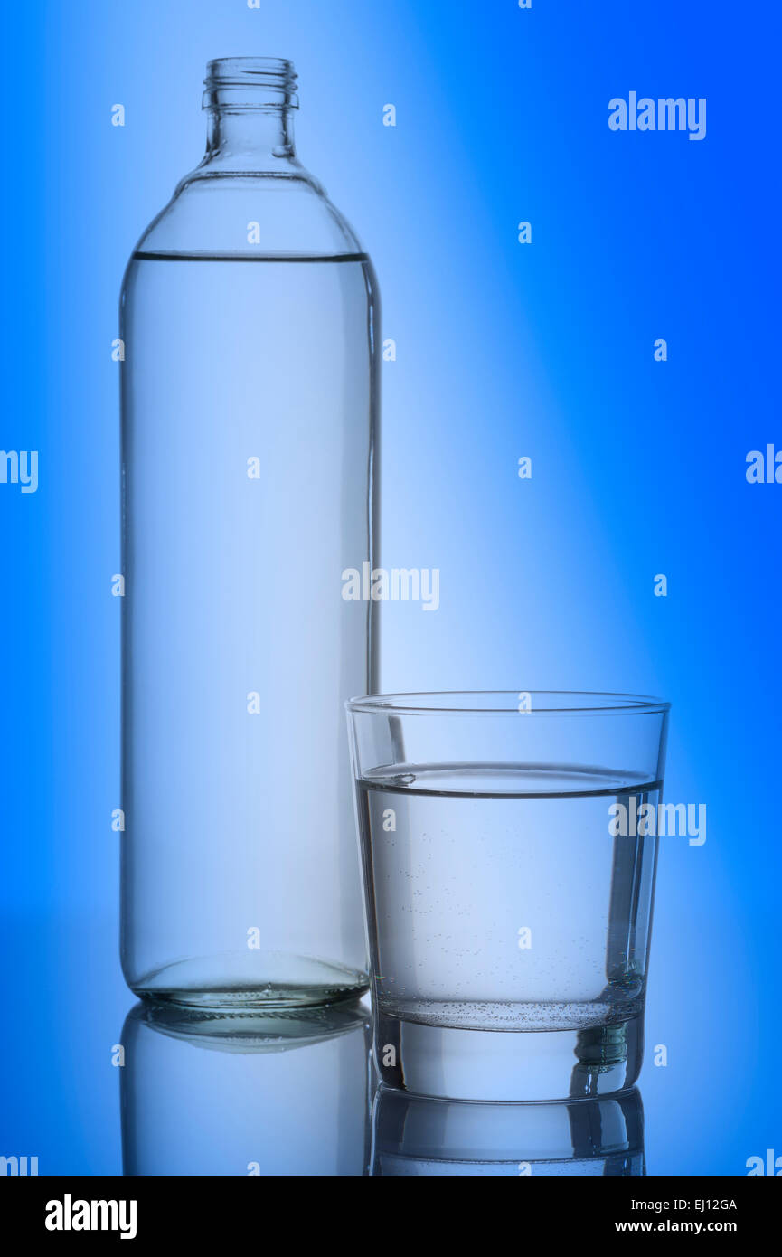 glass and bottle full of natural water, on blue background Stock Photo ...