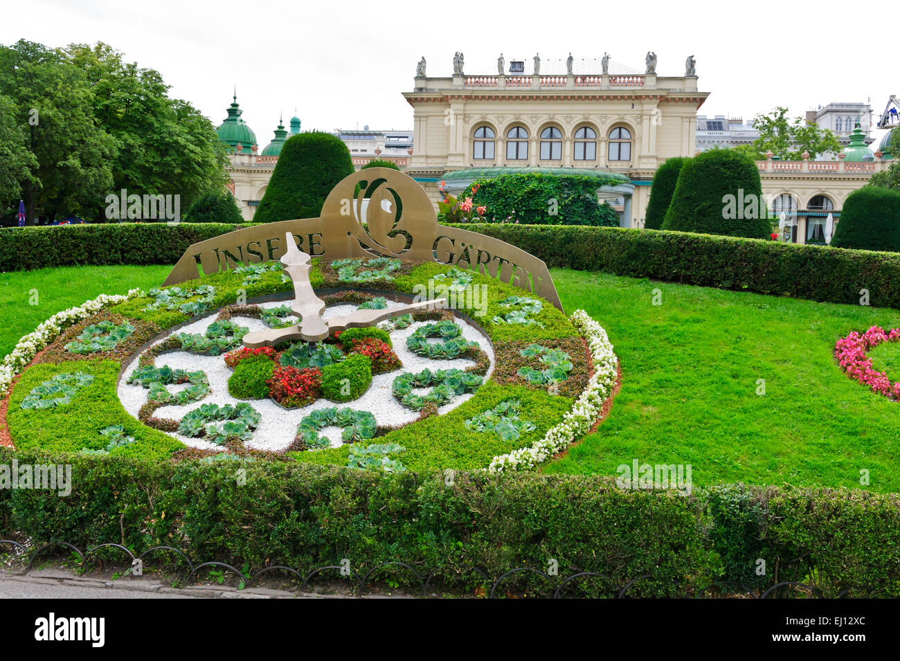 A huge clock made of greenery with Kursalon Huebner building in the distance in Stadtpark ...