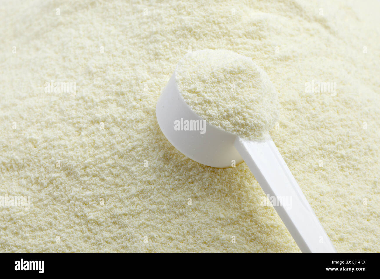 close up of powdered milk and spoon for baby on white background with ...