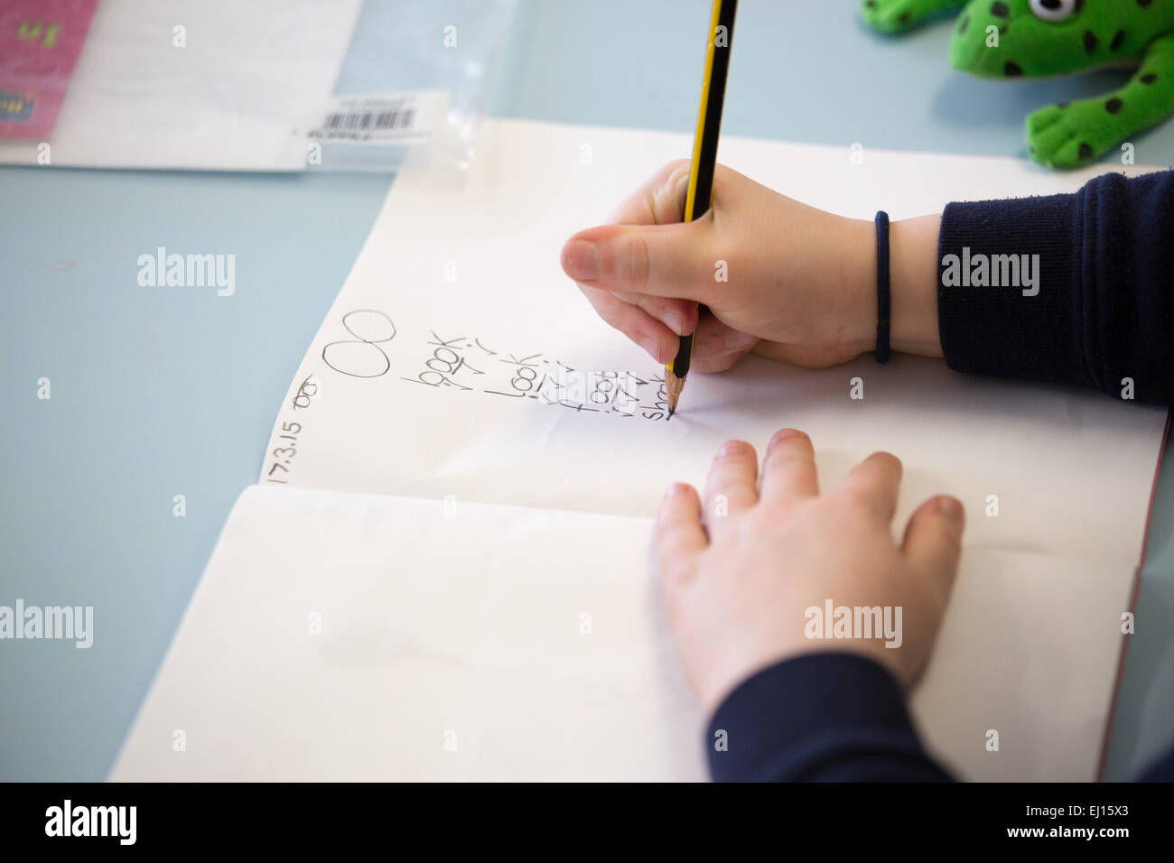 UK primary school pupil practicing writing in a literacy lesson Stock ...