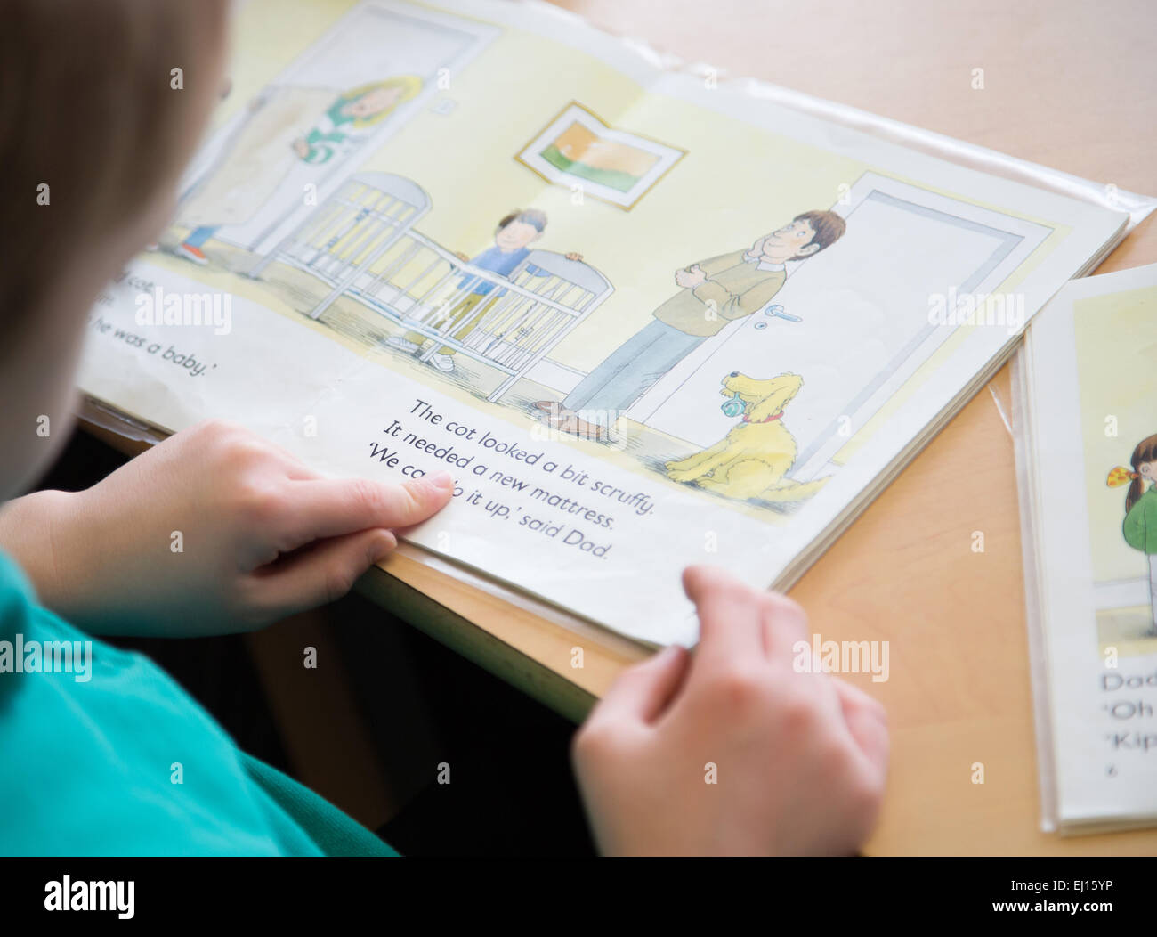 A UK primary school pupil learning to read in a UK classroom Stock ...