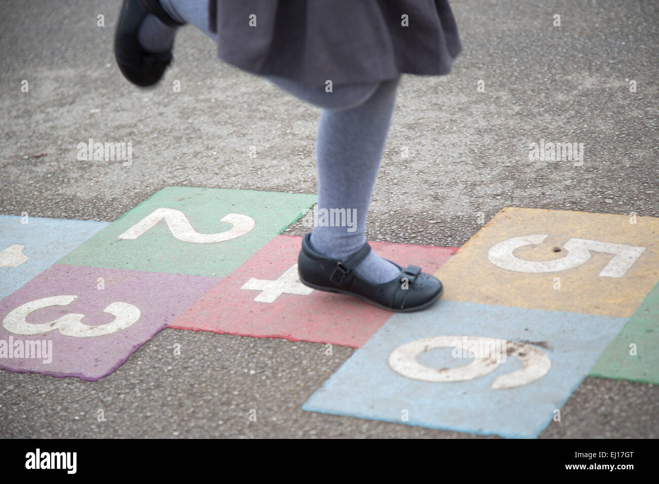 UK schoolgirl playing hopscotch in the playground of a UK primary ...