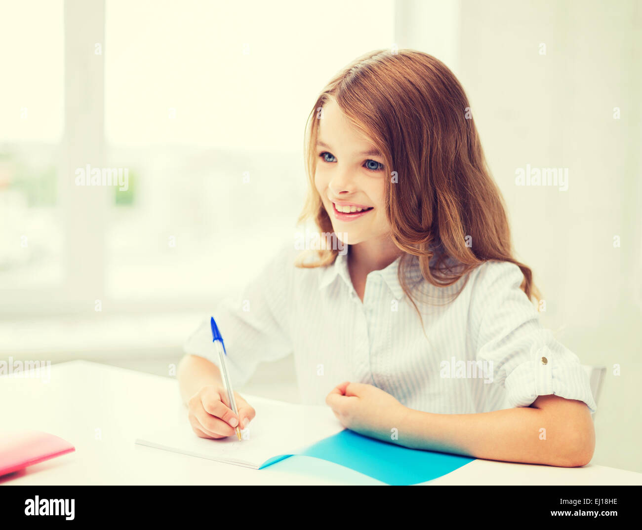 student girl writing in notebook at school Stock Photo - Alamy