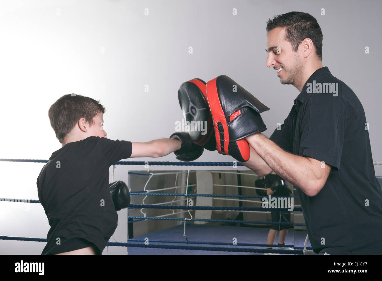 A coach with a child learning boxe Stock Photo - Alamy