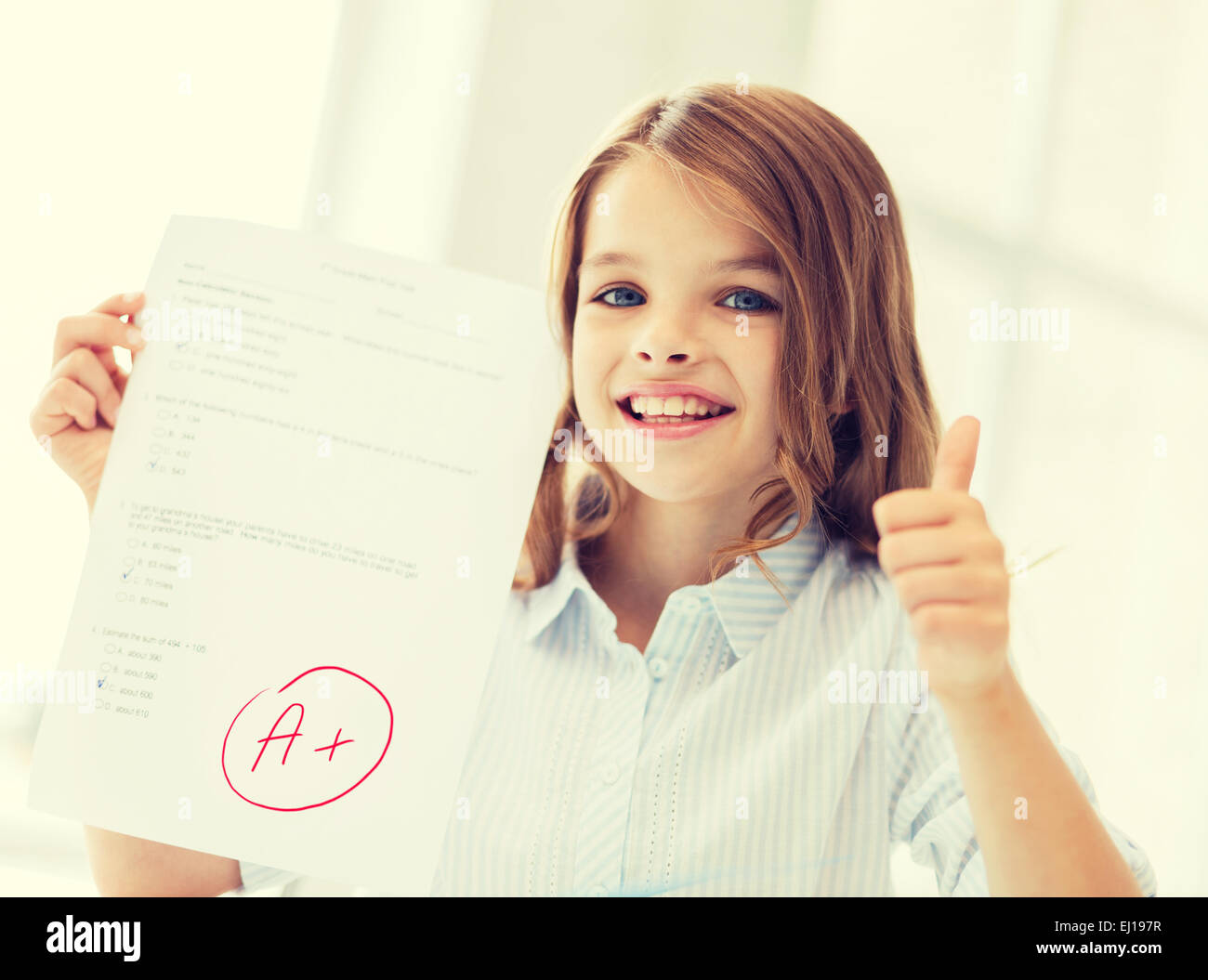 smiling little student girl with test and A grade Stock Photo - Alamy