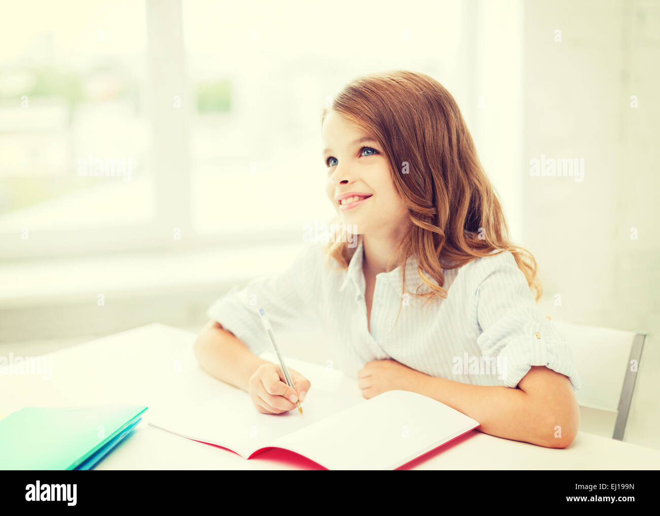 student girl writing in notebook at school Stock Photo - Alamy