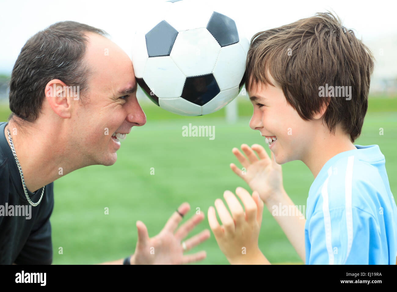 A young soccer player with father Stock Photo - Alamy