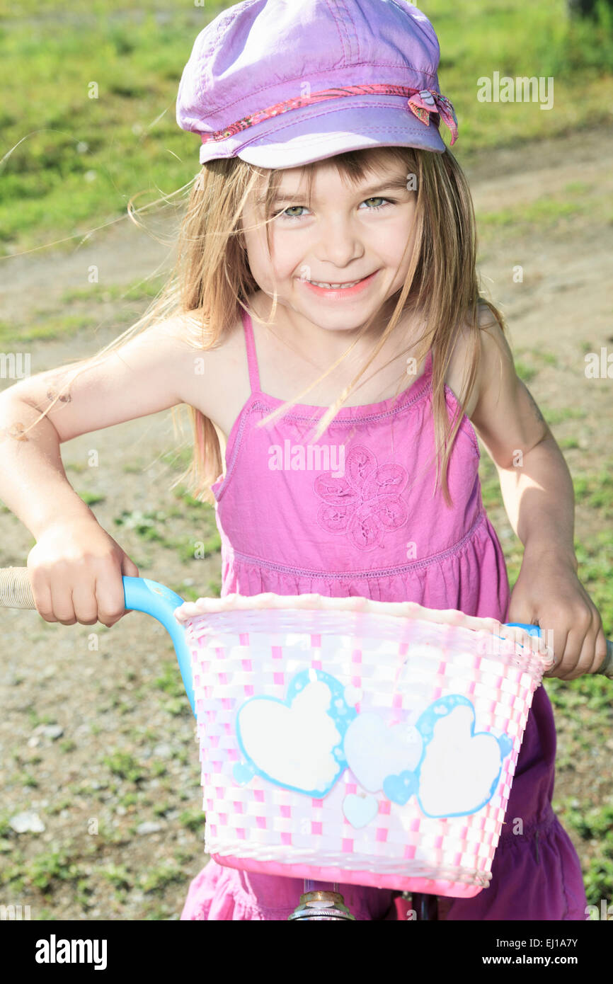 Little girl riding a bike on the country road Stock Photo - Alamy