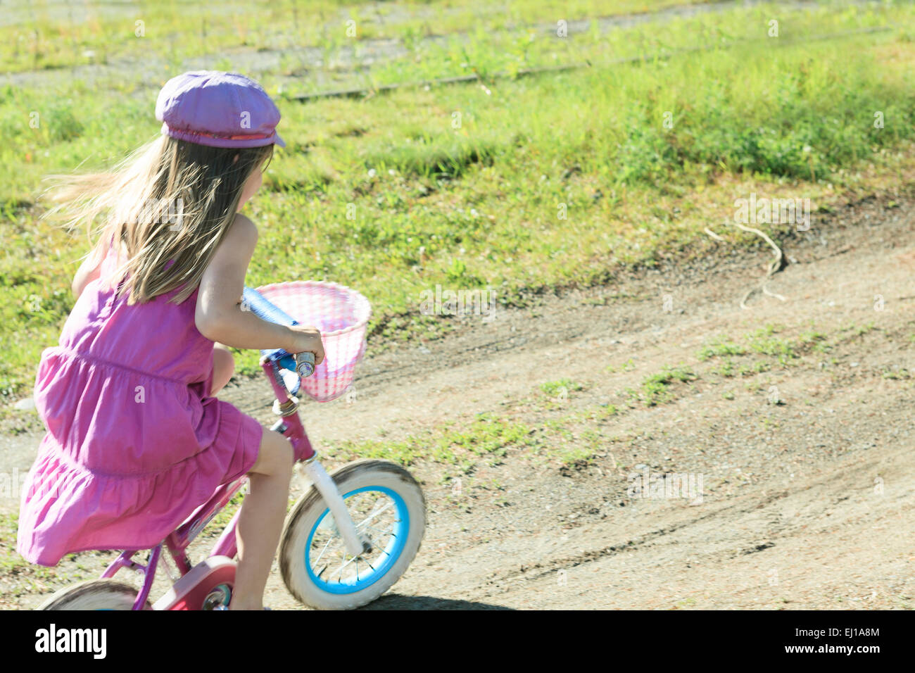 Little girl riding a bike on the country road Stock Photo - Alamy