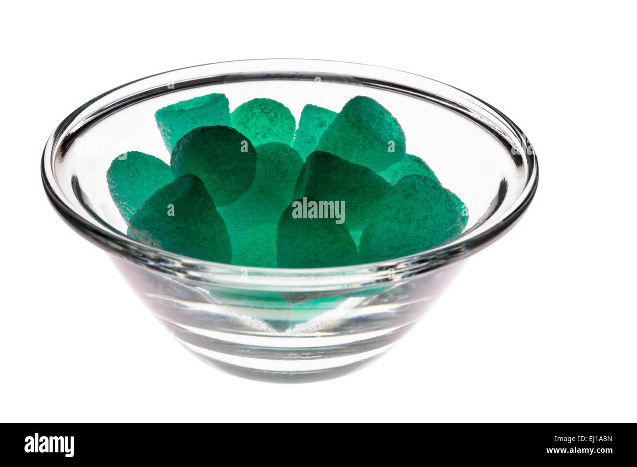 Jelly mints in glass cup on light table (illuminated from below) with ...